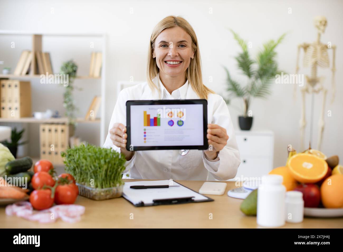 Caucasian female doctor holding tablet with charts of patients healthy ...