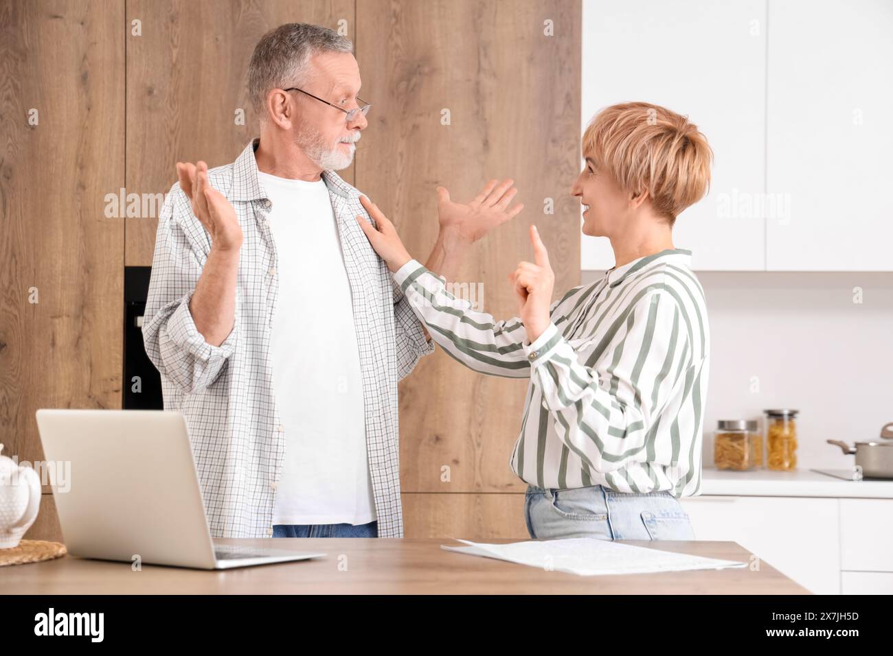Mature deaf mute couple using sign language in kitchen Stock Photo - Alamy