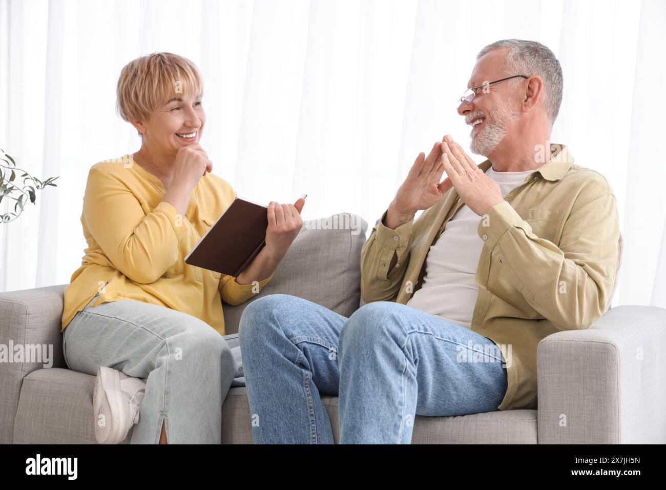 Mature deaf mute couple with book using sign language at home Stock ...