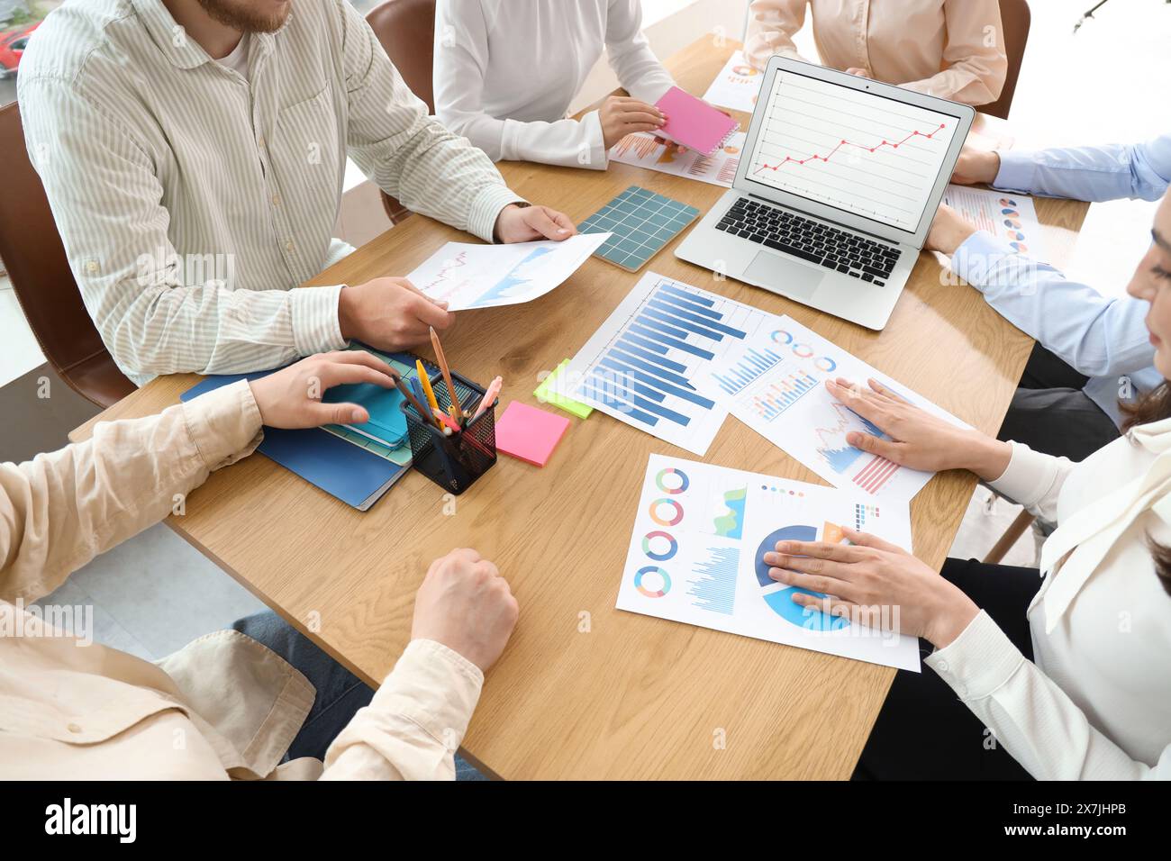 Business people with diagrams working on marketing plan in office ...