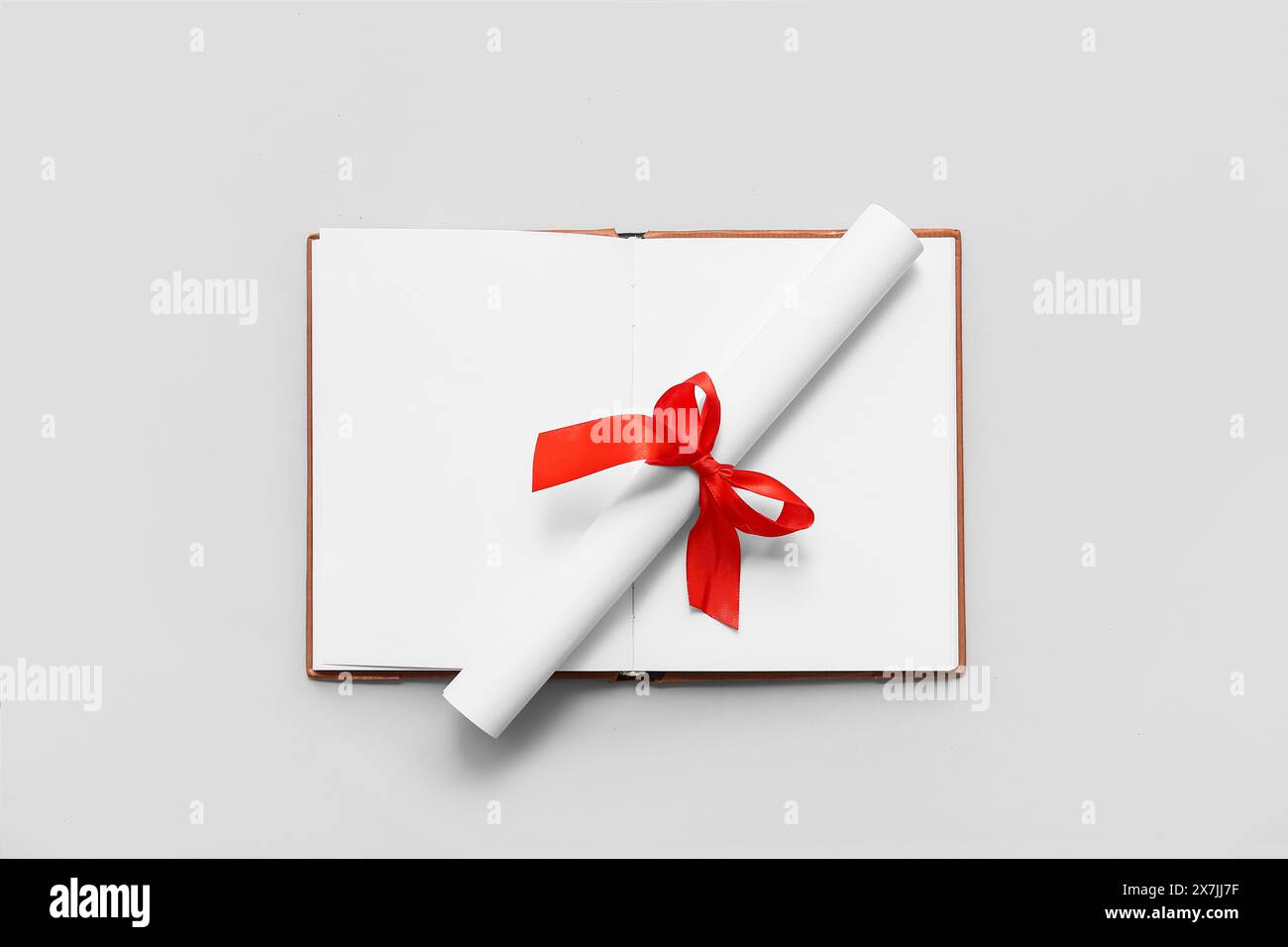 Diploma with red ribbon and opened book on white background Stock Photo ...