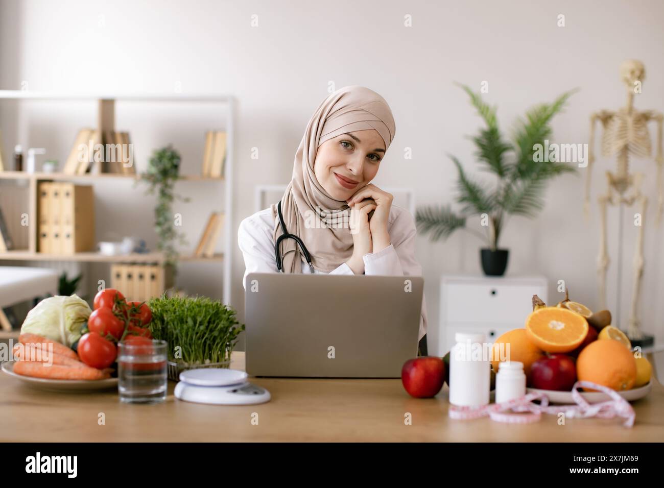 Nutritionist working on laptop and writing diet plan for patient Stock ...