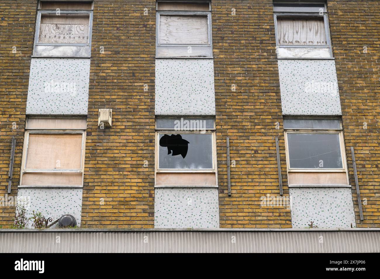 Broken and boarded up windows of closed down building, High Street ...