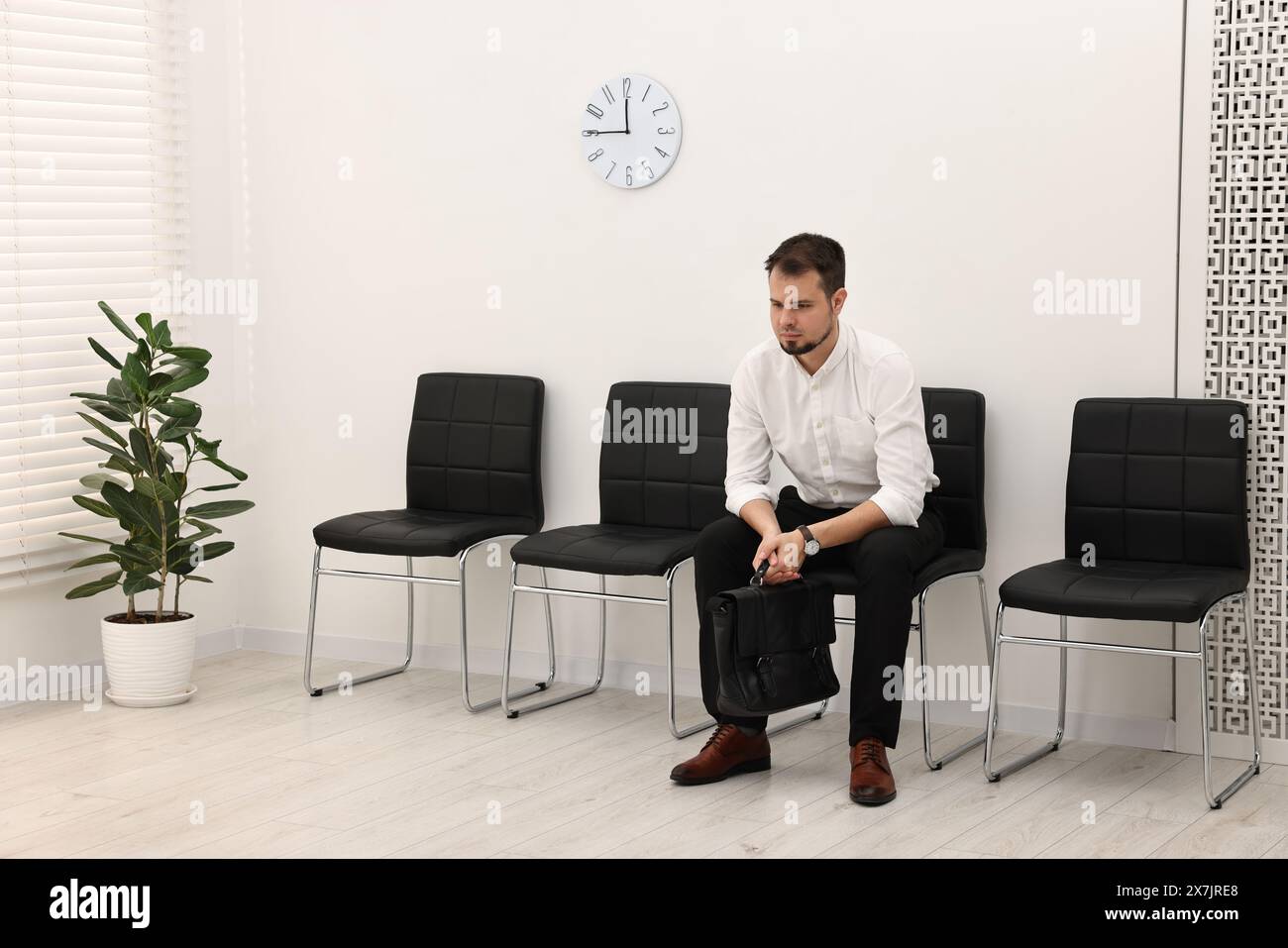 Man sitting on chair and waiting for job interview indoors Stock Photo ...