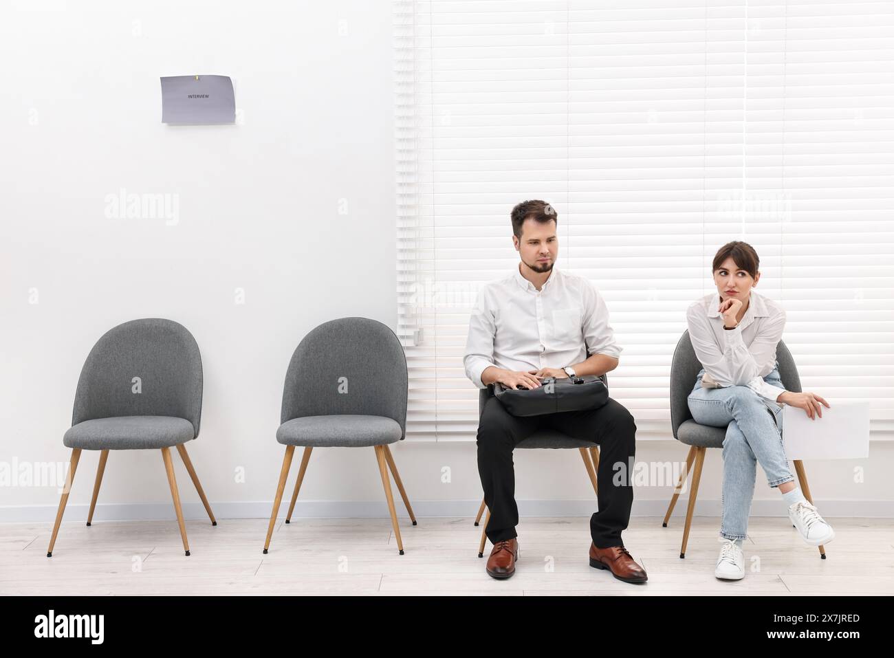 Man and woman waiting for job interview indoors Stock Photo - Alamy