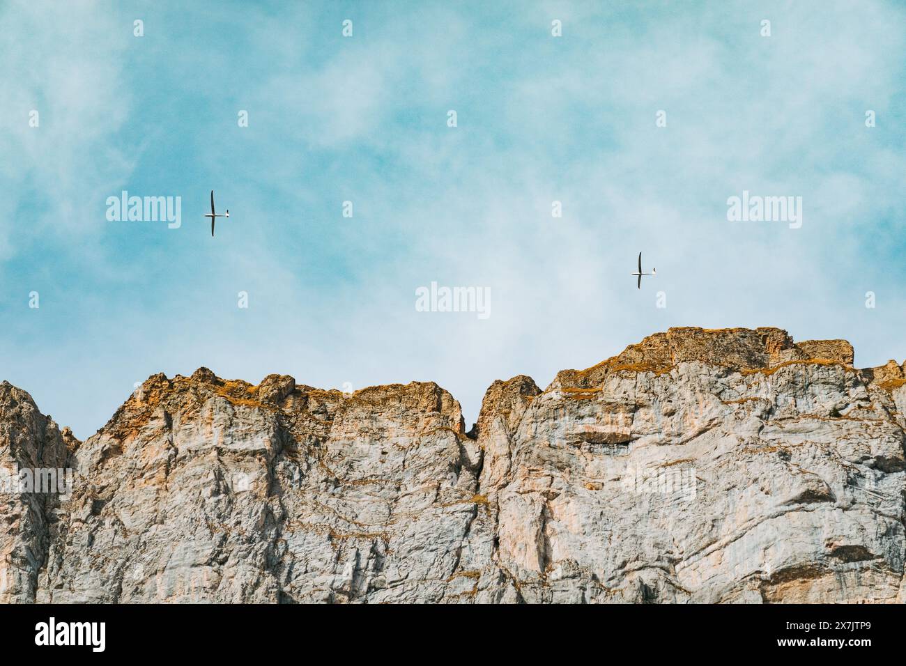 Two gliders soaring above the rocky cliffs of the Churfirsten mountain ...