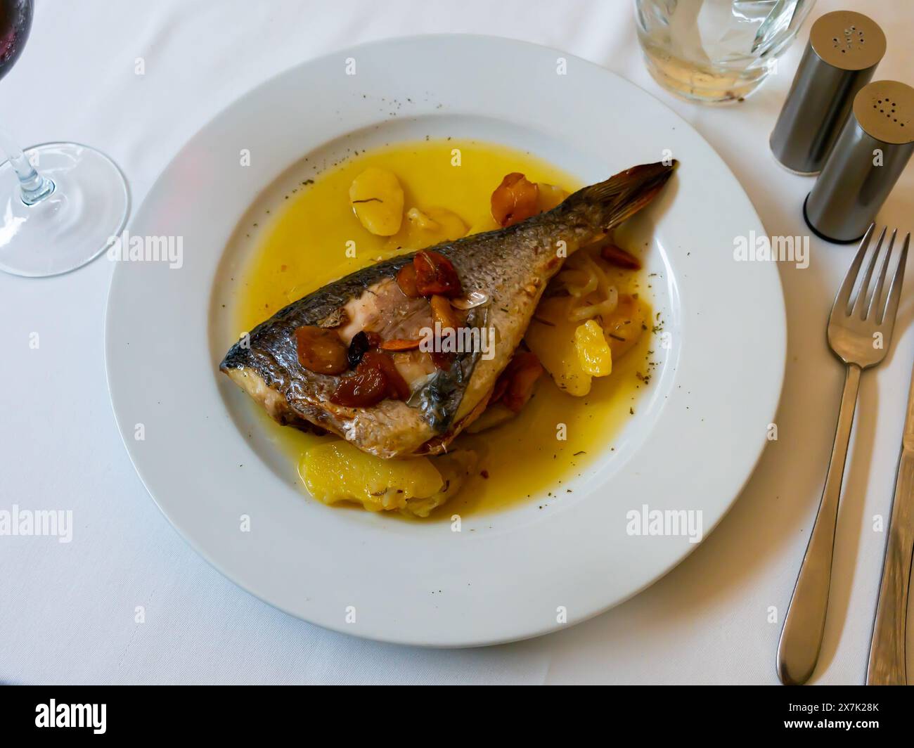 Grilled gilthead bream with stewed potato slices in sauce Stock Photo ...