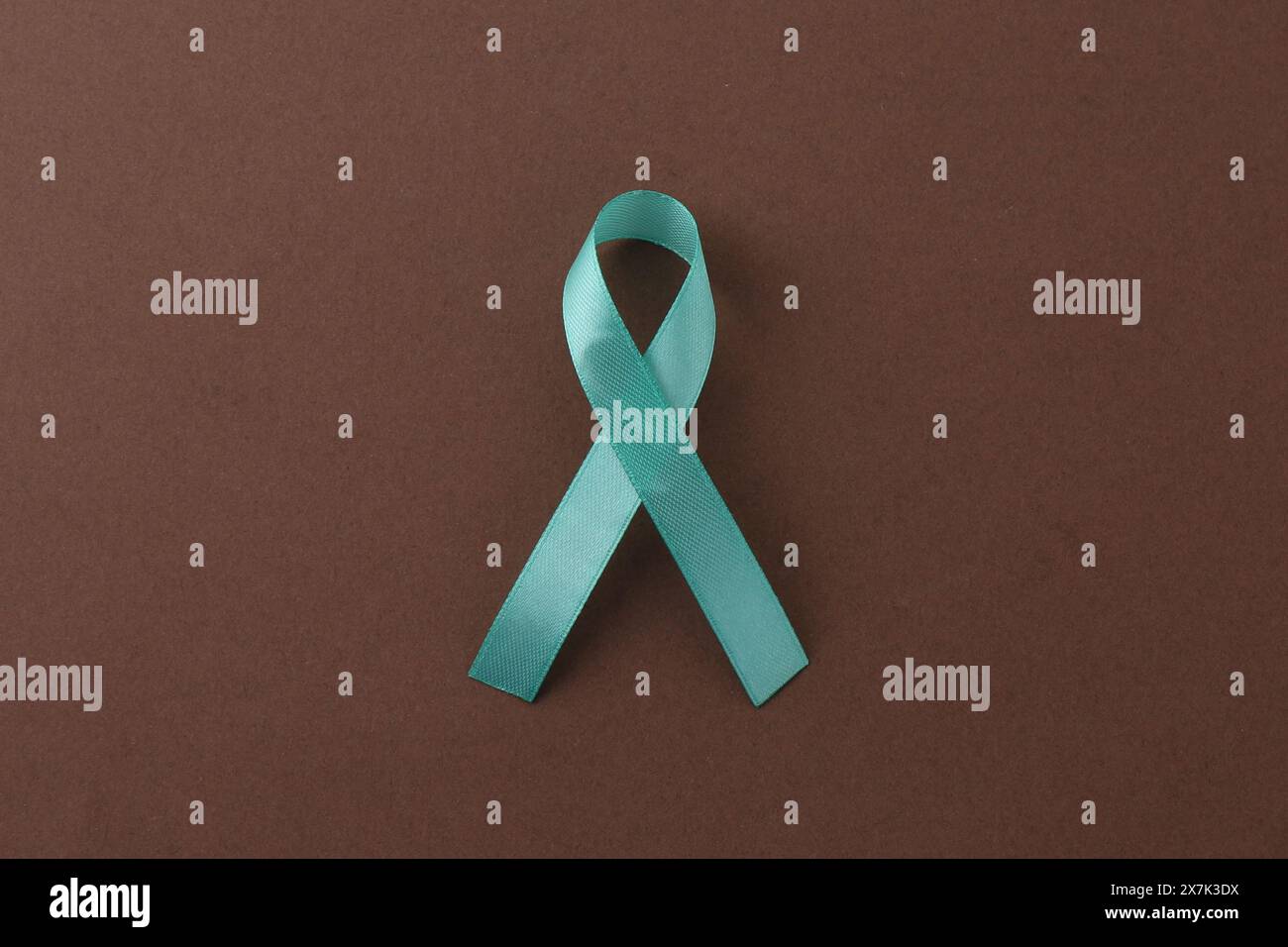Turquoise awareness ribbon on brown background, top view Stock Photo ...