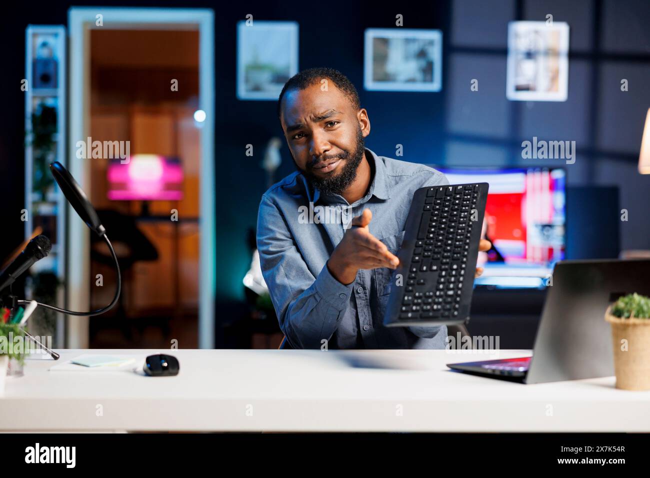 Content creator holding mechanical keyboard in hand, showing ...