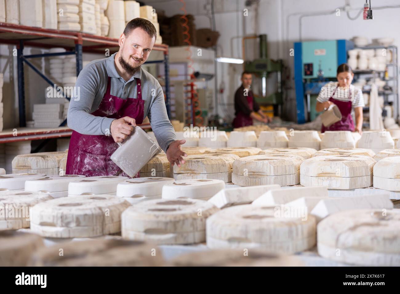 Young man pouring clay into mold Stock Photo - Alamy