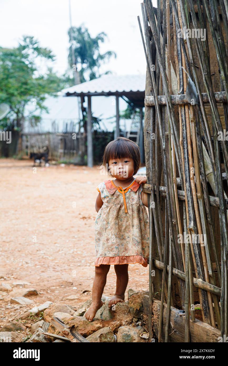 Small cute local female villager child in a grubby dress in a Lahu ...