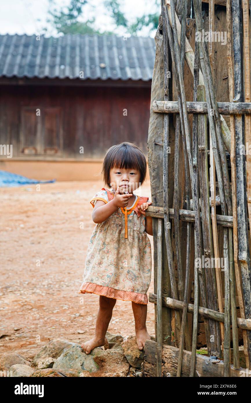 Small cute local female villager child in a grubby dress in a Lahu ...