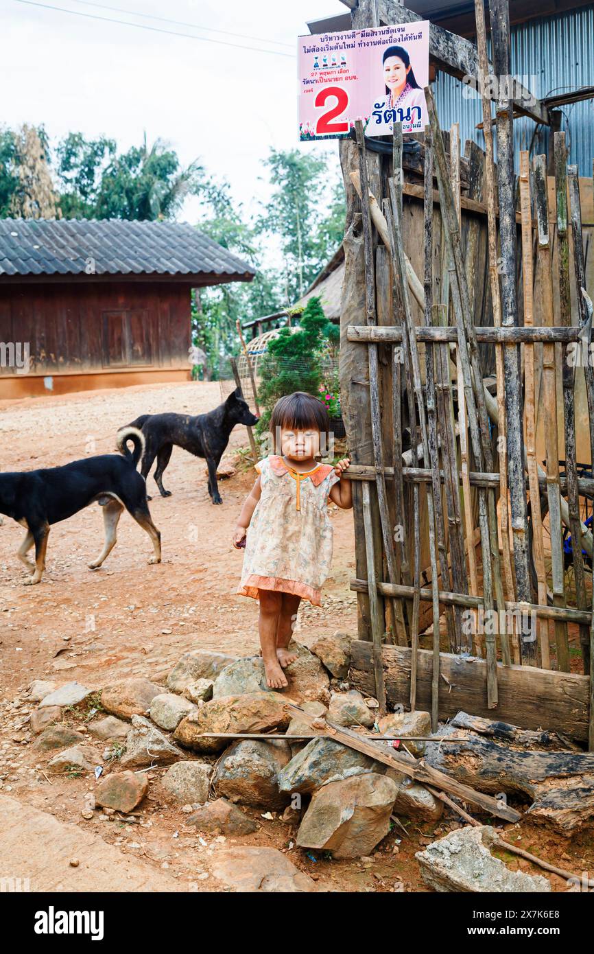 Small cute local female villager child in a grubby dress in a Lahu ...