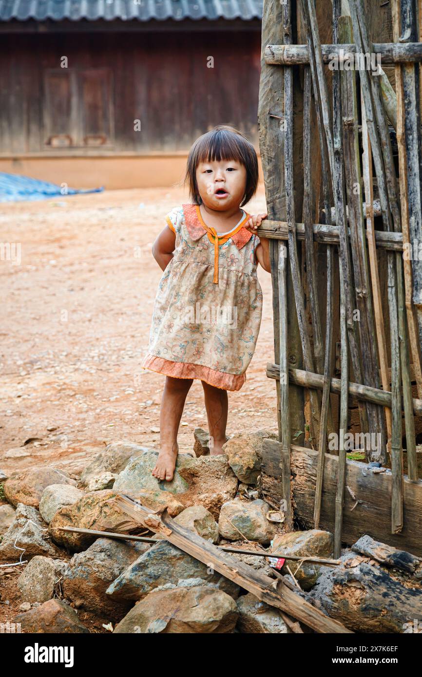 Small cute local female villager child in a grubby dress in a Lahu ...