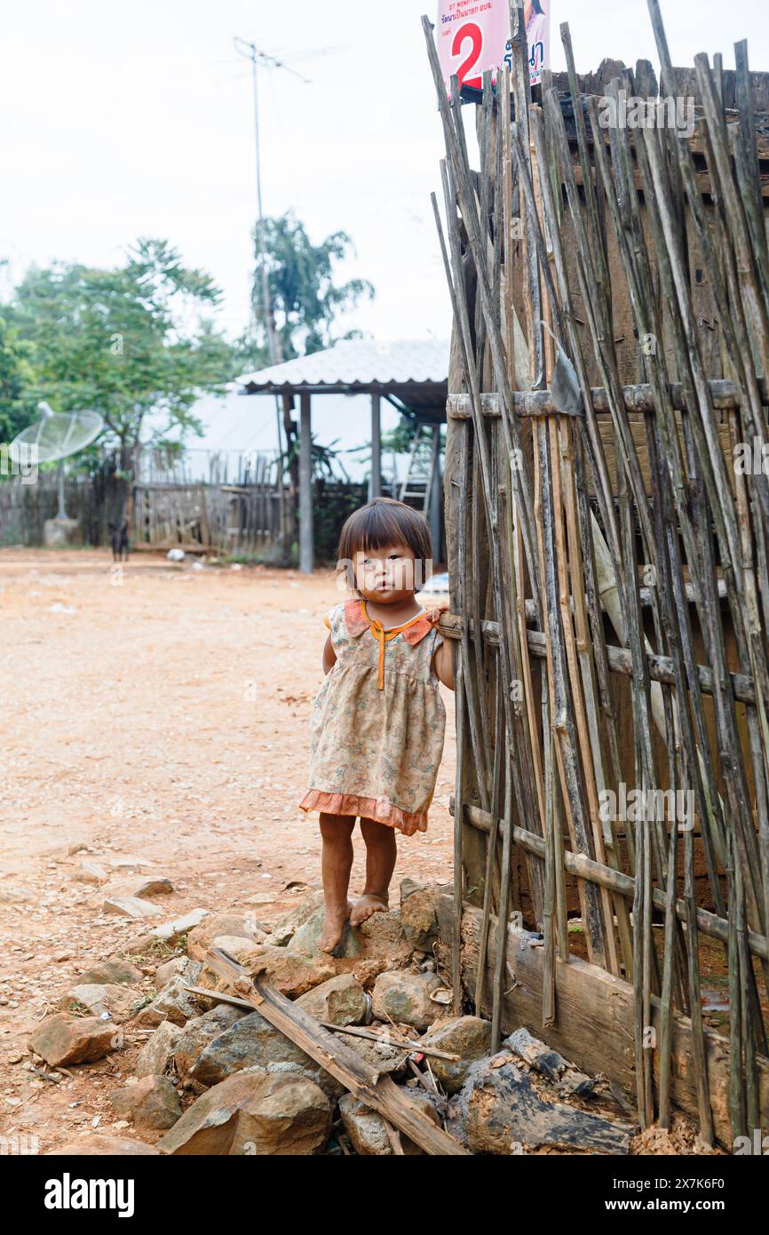 Small cute local female villager child in a grubby dress in a Lahu ...
