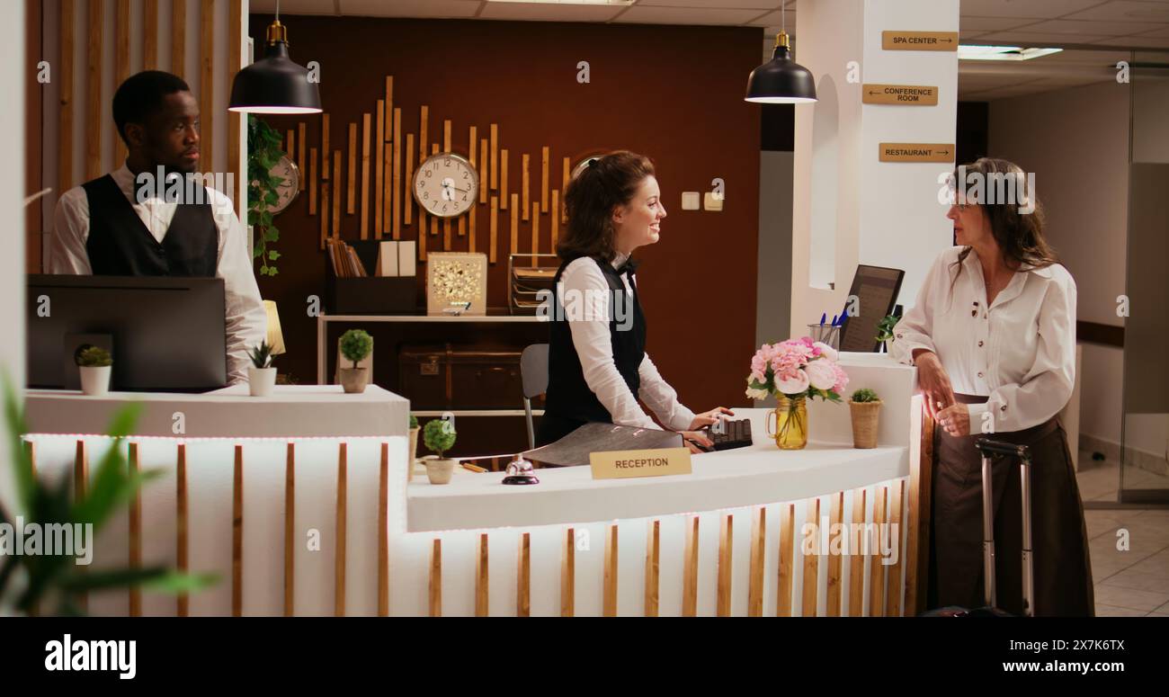 Elderly person arriving in hotel lobby, asking concierge about senior ...