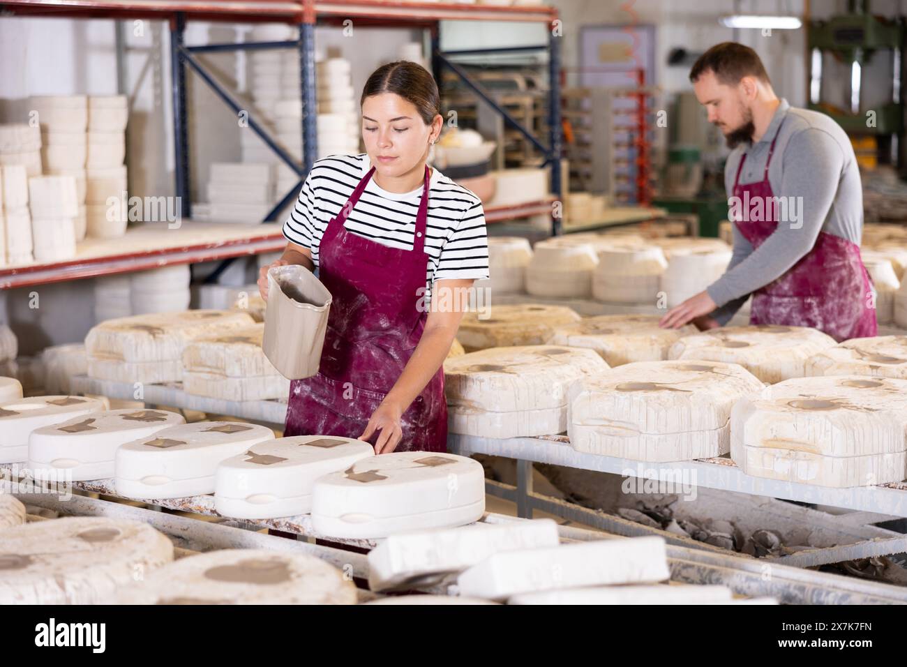 Female artisan pouring slip into casting molds in workshop Stock Photo ...