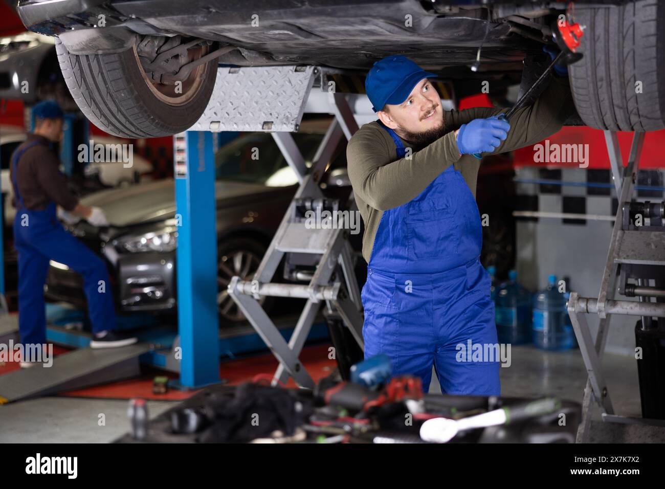Mechanic is repairing a car - replacing the wheel ball joint of car ...
