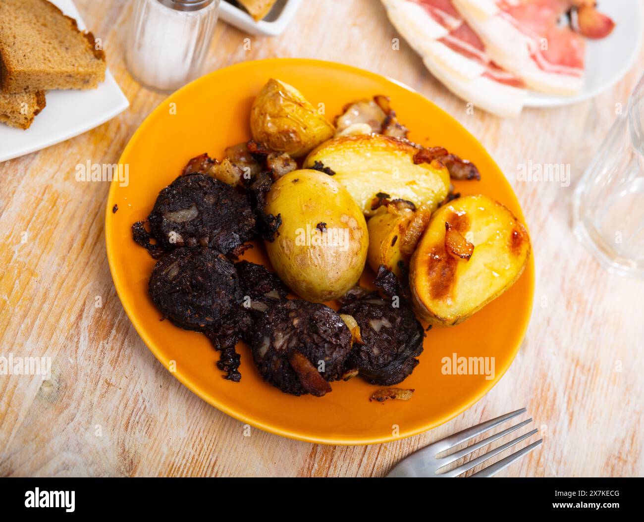 Fried blood sausage with potatoes served at plate Stock Photo - Alamy