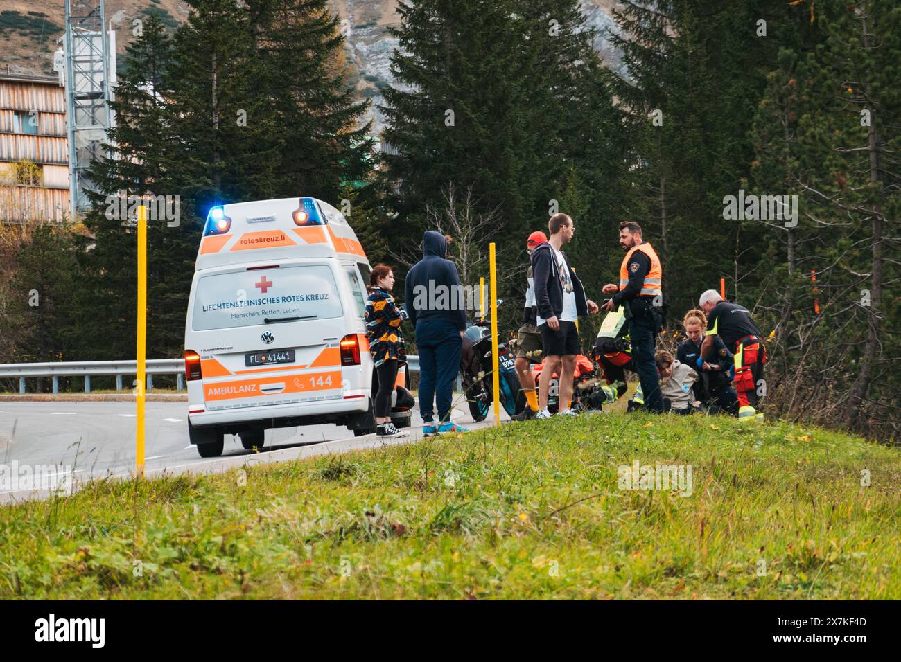 A Liechtenstein Red Cross ambulance is parked on a winding mountain ...
