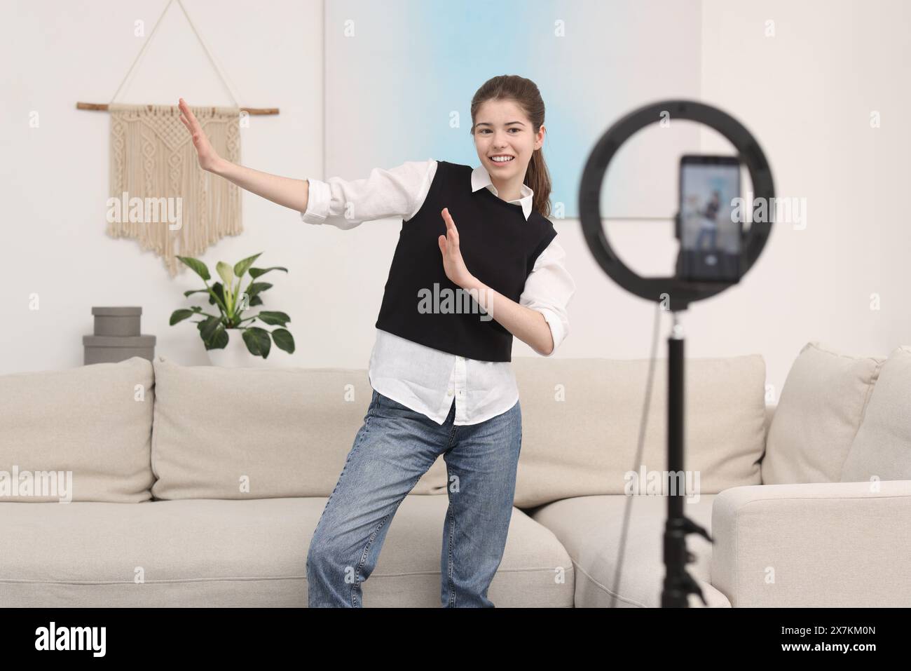 Smiling teenage blogger dancing while streaming at home Stock Photo - Alamy