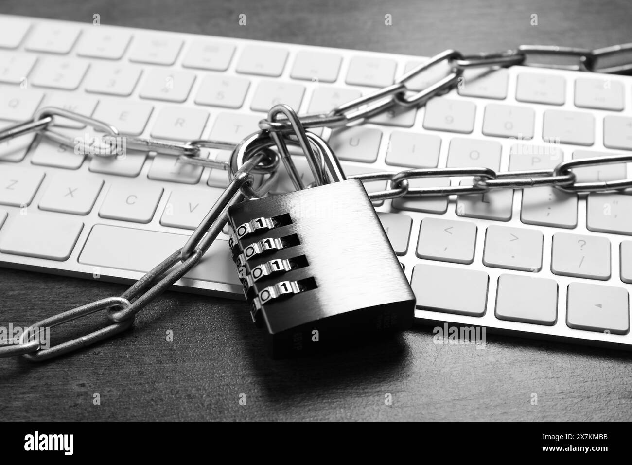 Cyber security. Metal combination padlock with chain and keyboard on grey table, closeup Stock ...