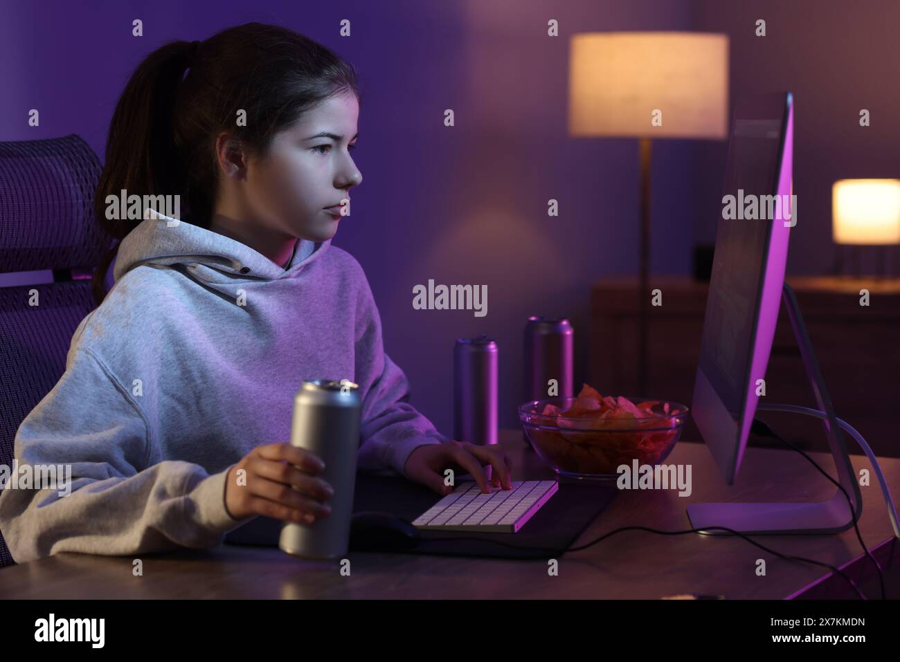 Girl with energy drink playing computer game at home Stock Photo - Alamy