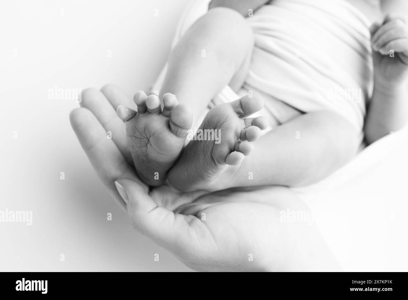 The palms of the father, the mother are holding the foot of the newborn ...