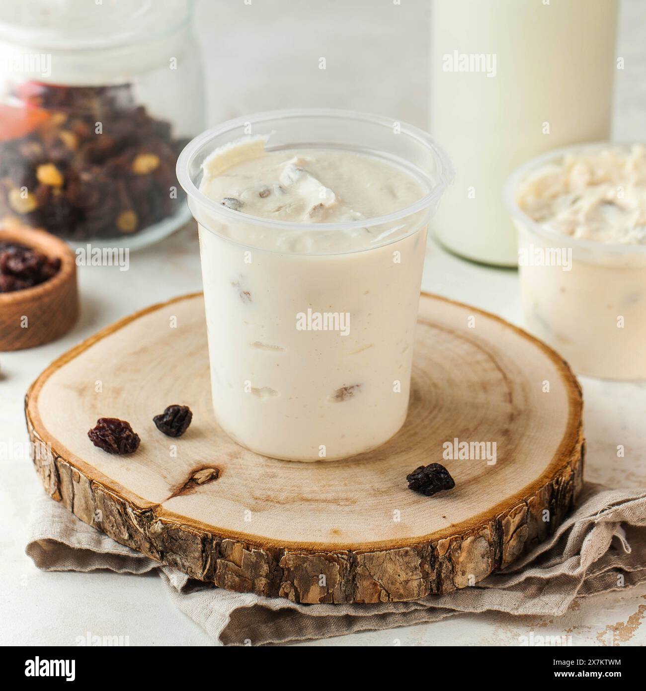 Cottage cheese made from natural milk with raisins in a plastic jar ...