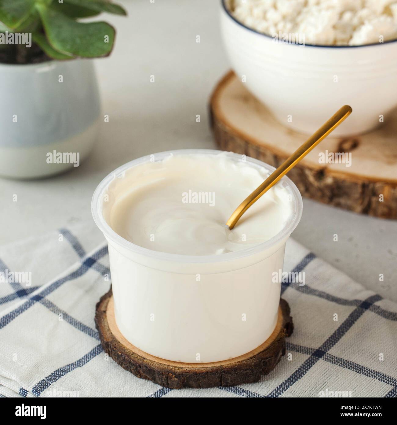 Natural sour cream in a plastic cup made from farm milk. Fermented milk ...