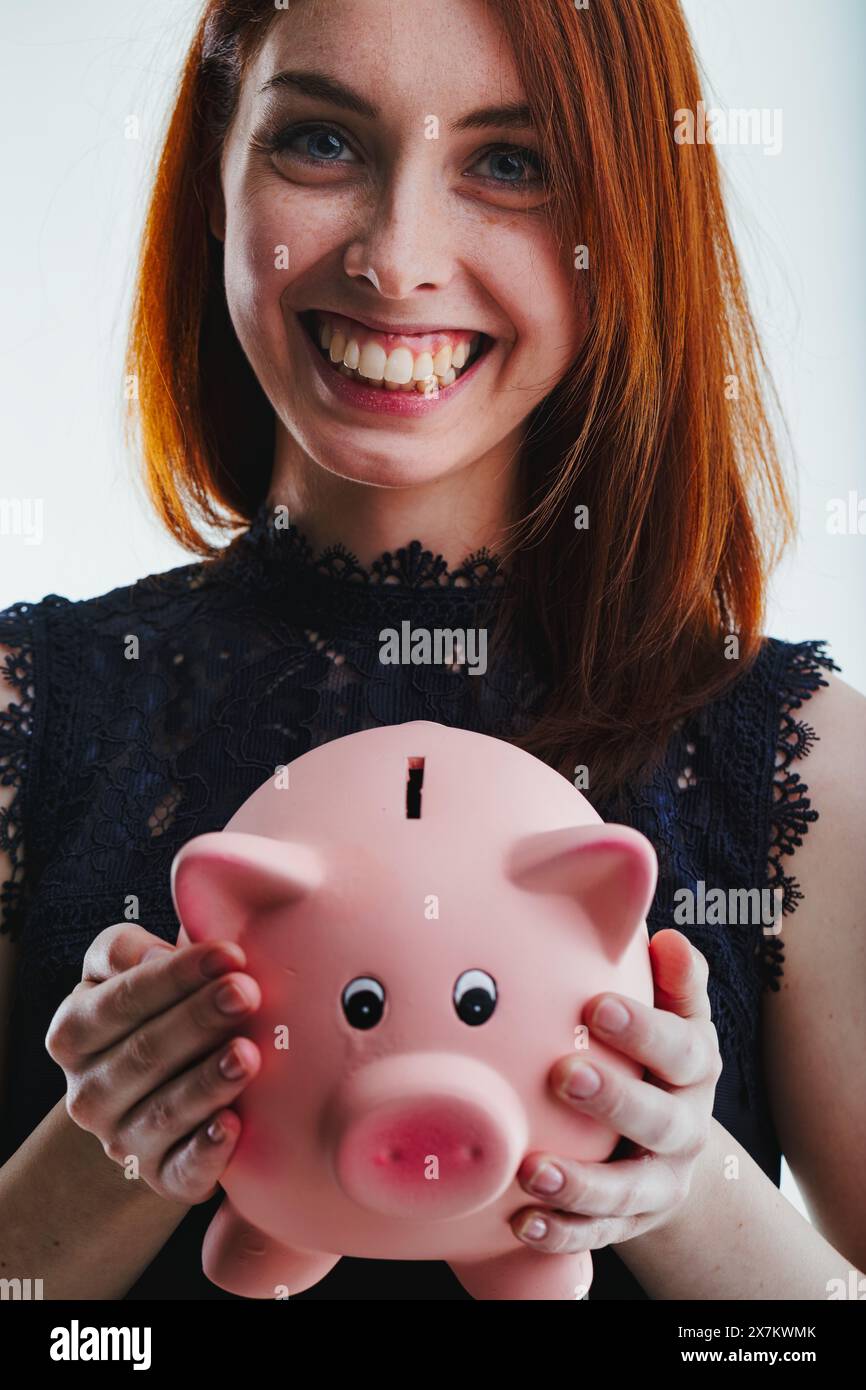 With a wide smile, a red-haired woman in a black lace top displays a ...