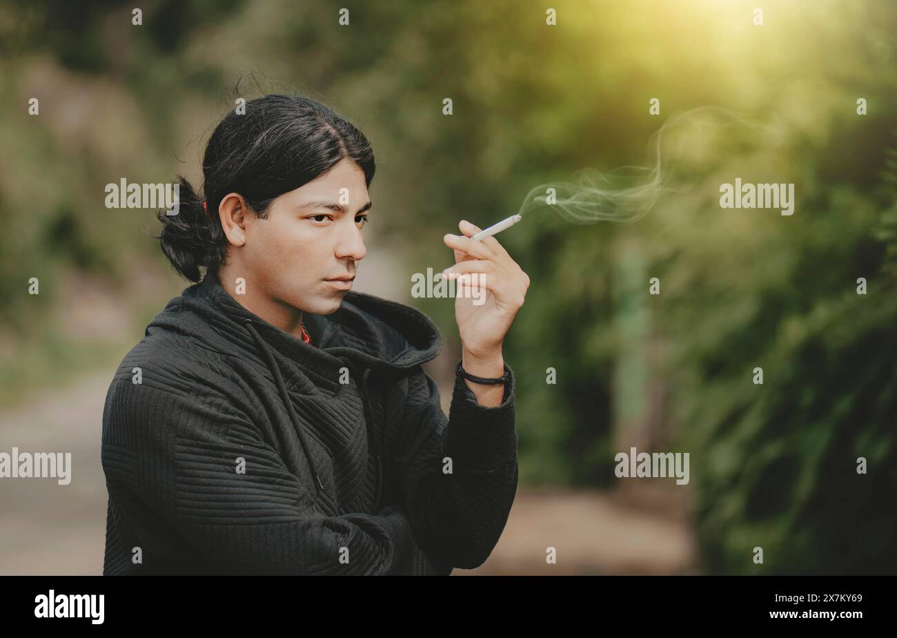 Portrait of handsome guy smoking outdoors. Young man smoking cigarette ...