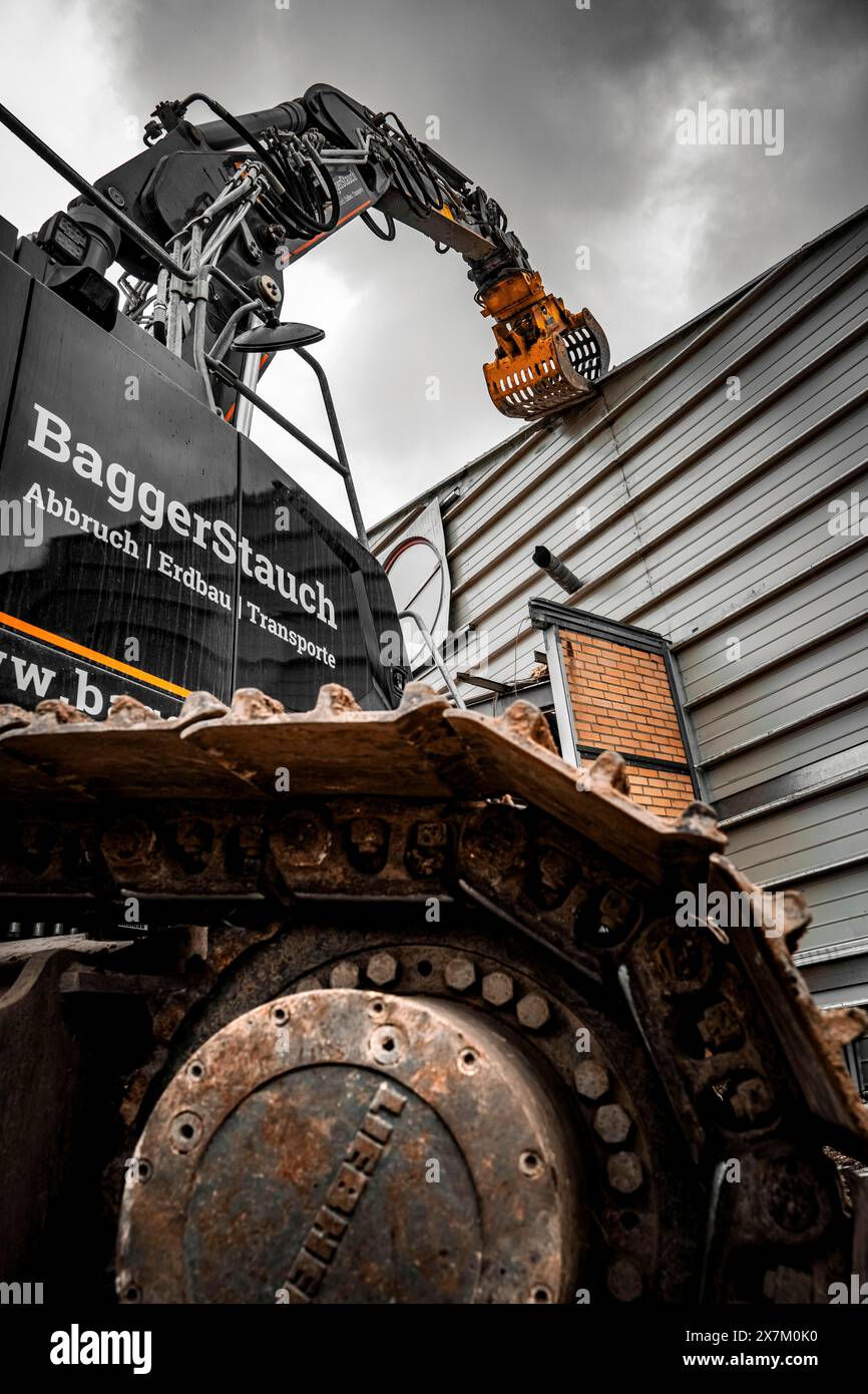A large excavator grabs a metal structure with a mechanical grab under ...