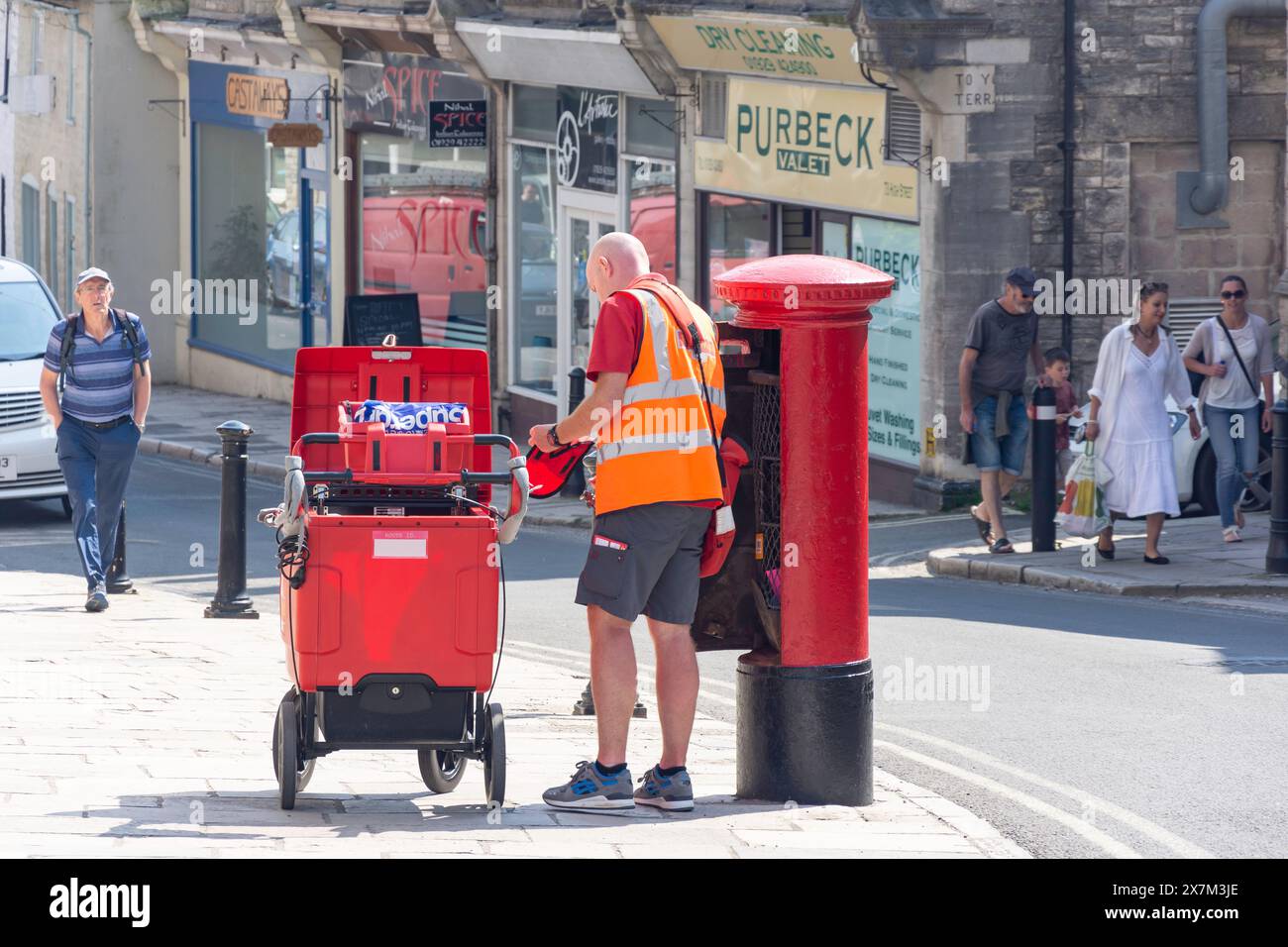 Royal Mail postman emptying a post box, High Street, Swanage, Isle of ...
