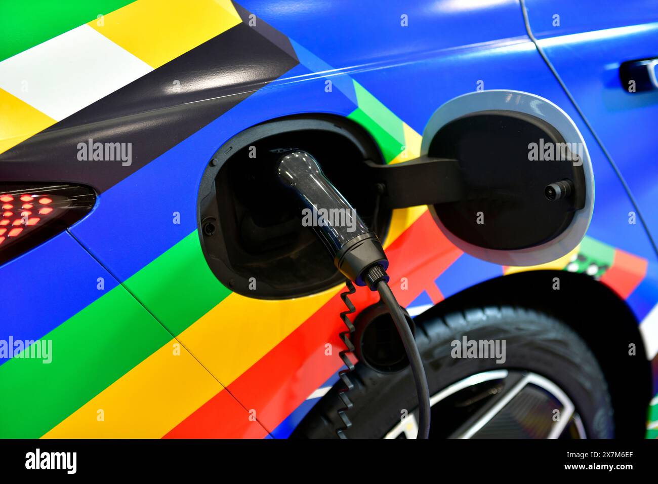 Electric Vehicle charging in station with power supply plugged into an ...