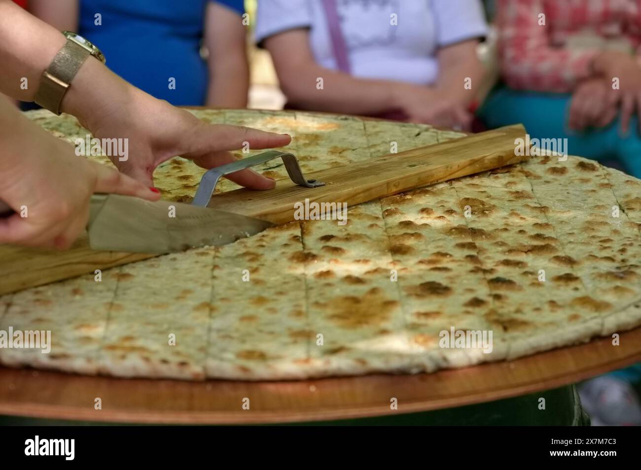 Womans hands cutting soparnik - traditional Croatian food on big wooden ...