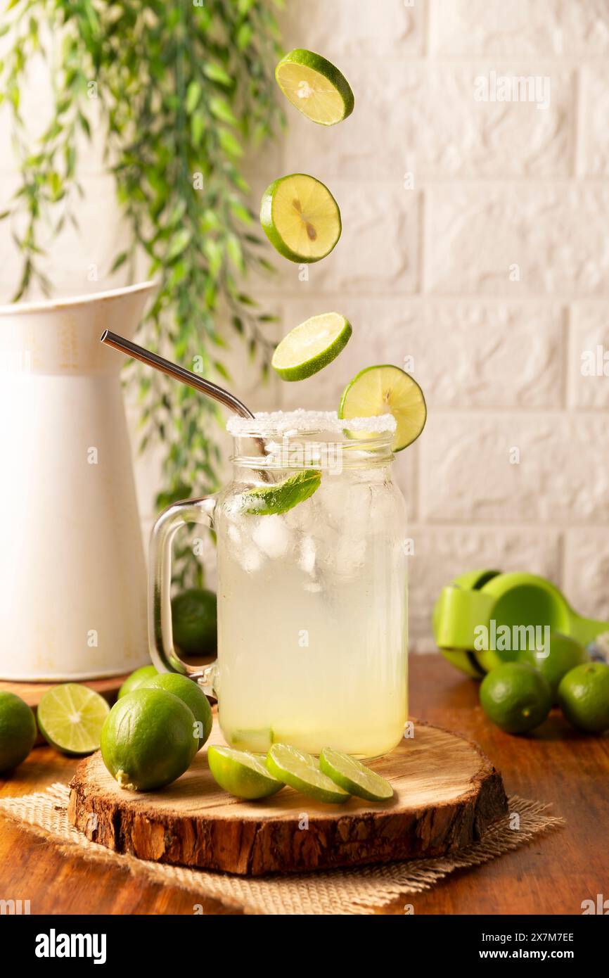 Slices of fresh lemons falling on glass with homemade lemonade, glass ...