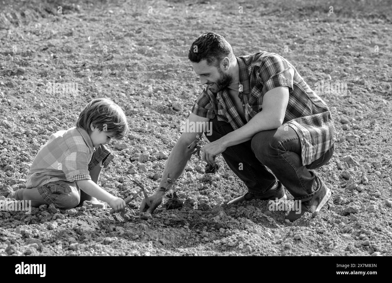 Father teaching his son gardening. Son helping his father to plant the ...