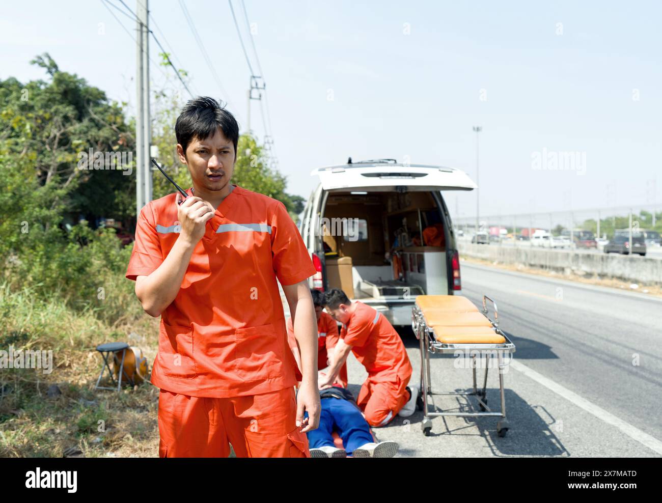 Asian rescue staff in orange uniform use walkie talkie to coordinate ...