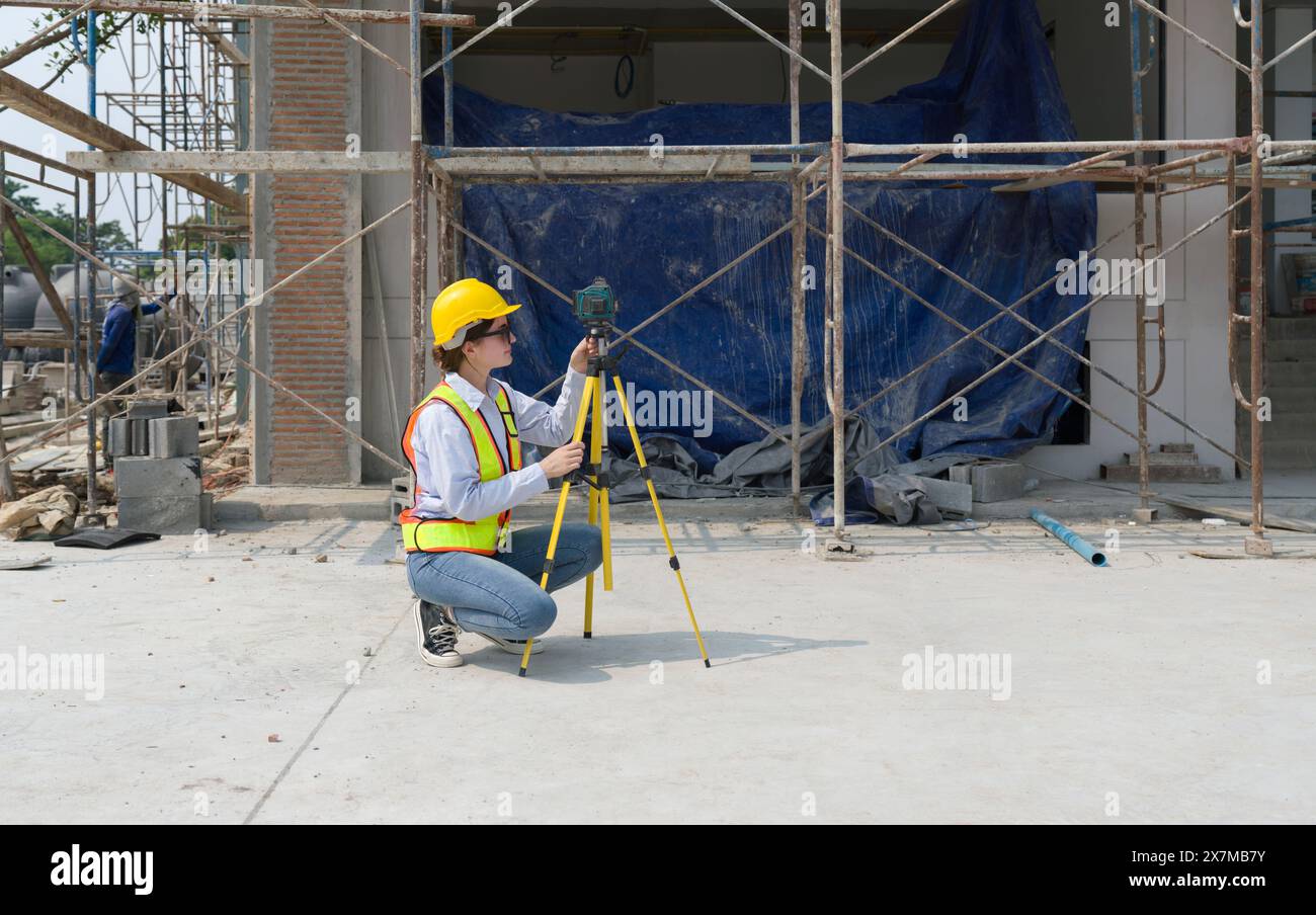 A construction worker is using a laser gauge to capture the setting of ...