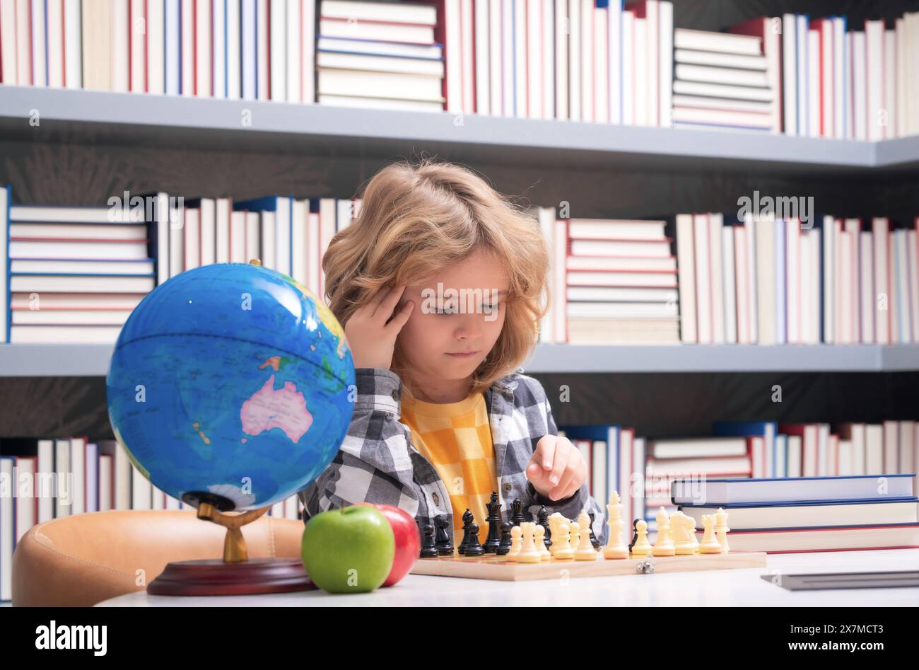 Child play chess. Clever concentrated and thinking child playing chess ...