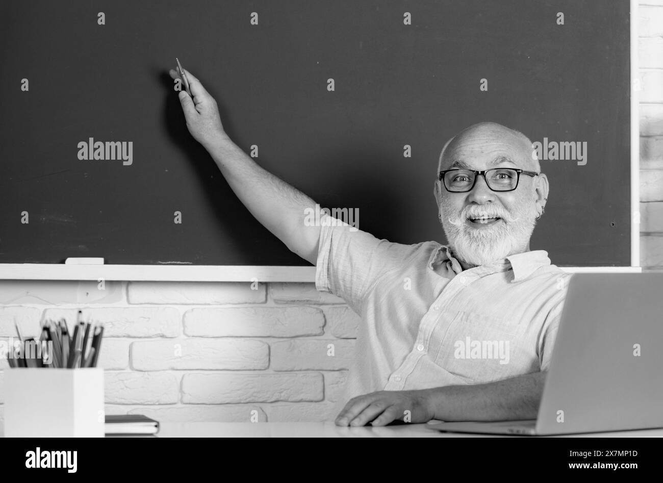 Portrait of senior teacher in classroom. Back to school. Learning ...