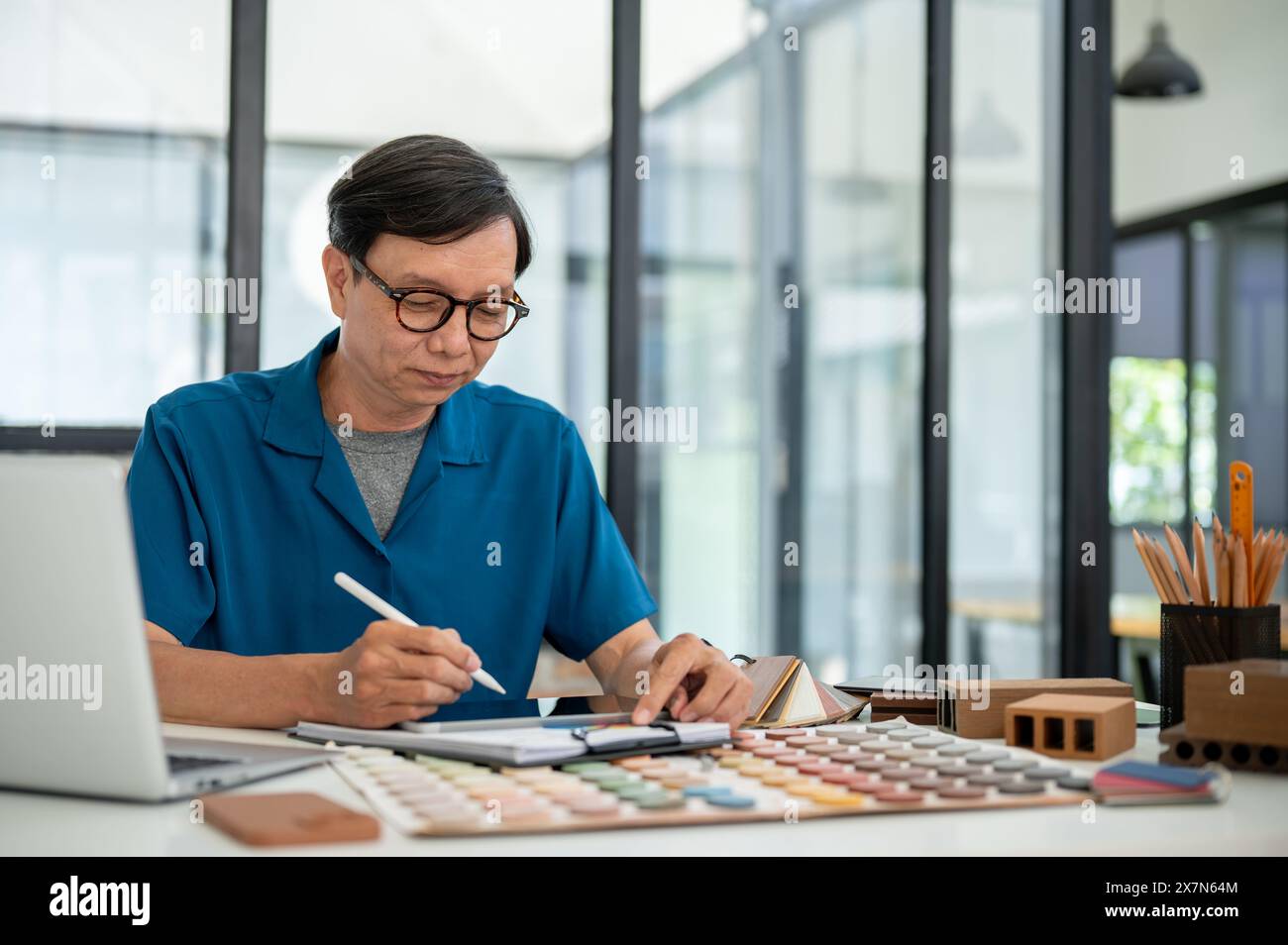 A professional senior Asian male interior designer is designing the ...