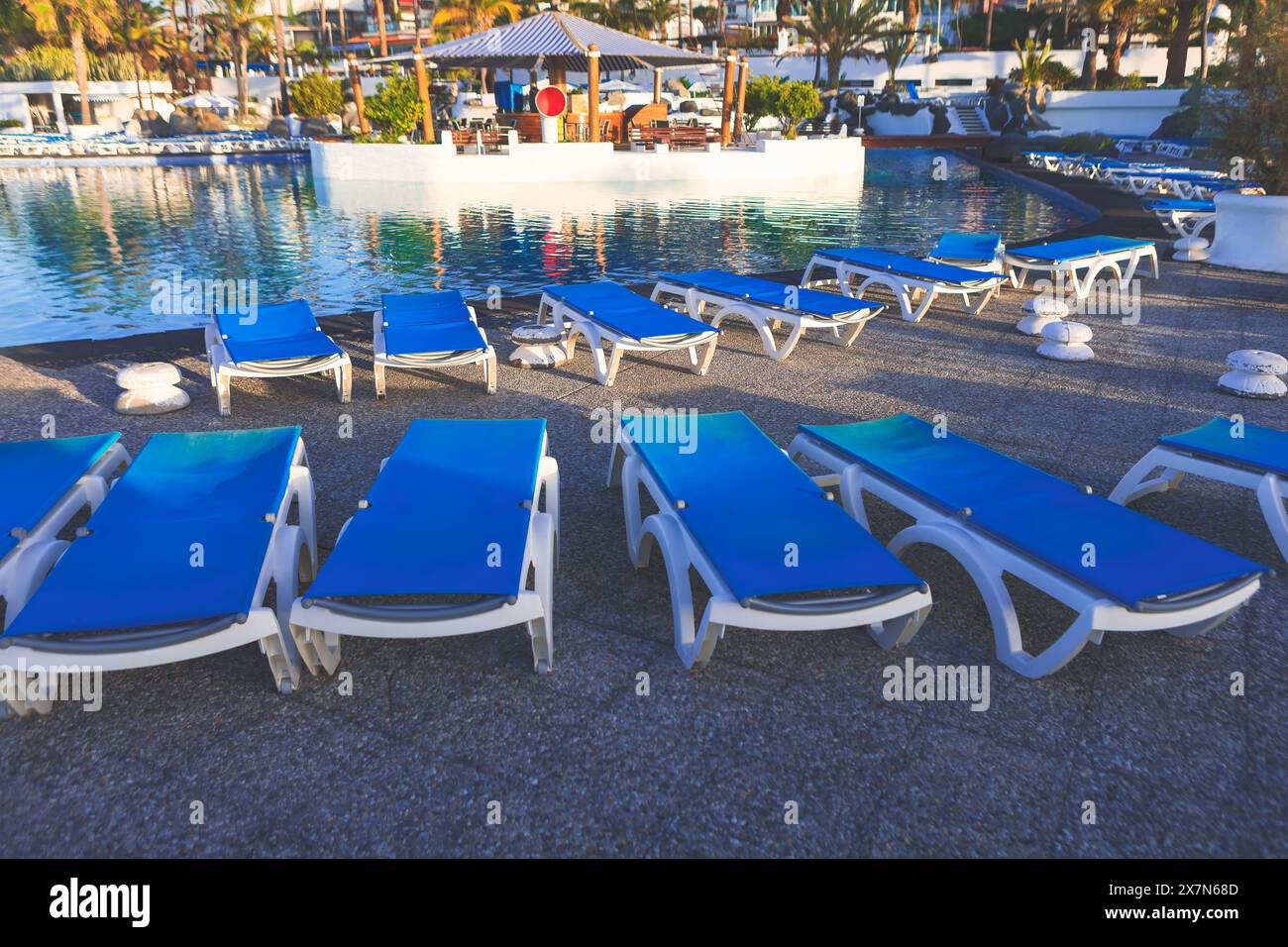 Lounge chairs by a pool, perfect for relaxing under the sun on vacation ...