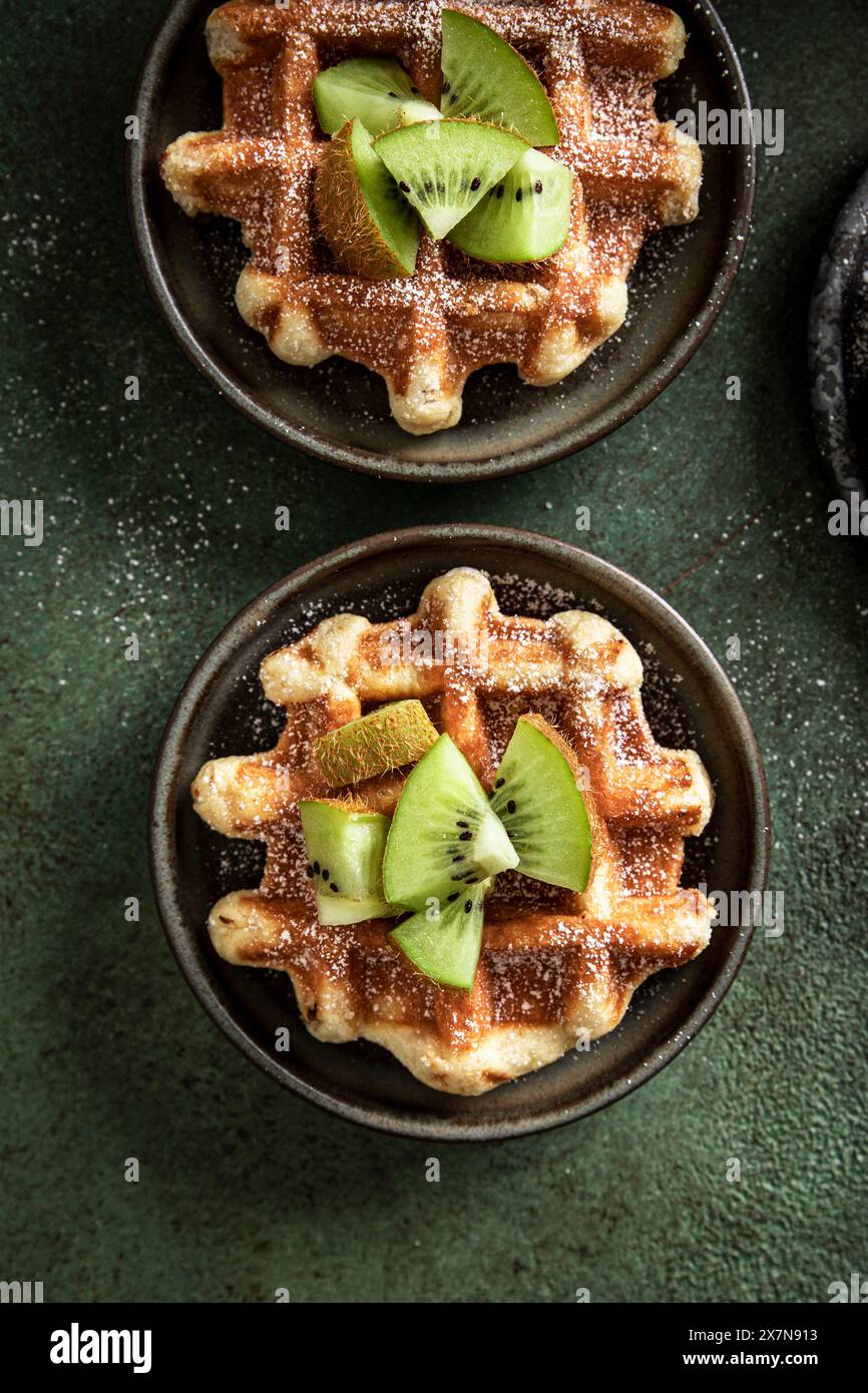 Morning waffles with kiwi and fork on a green surface Stock Photo - Alamy