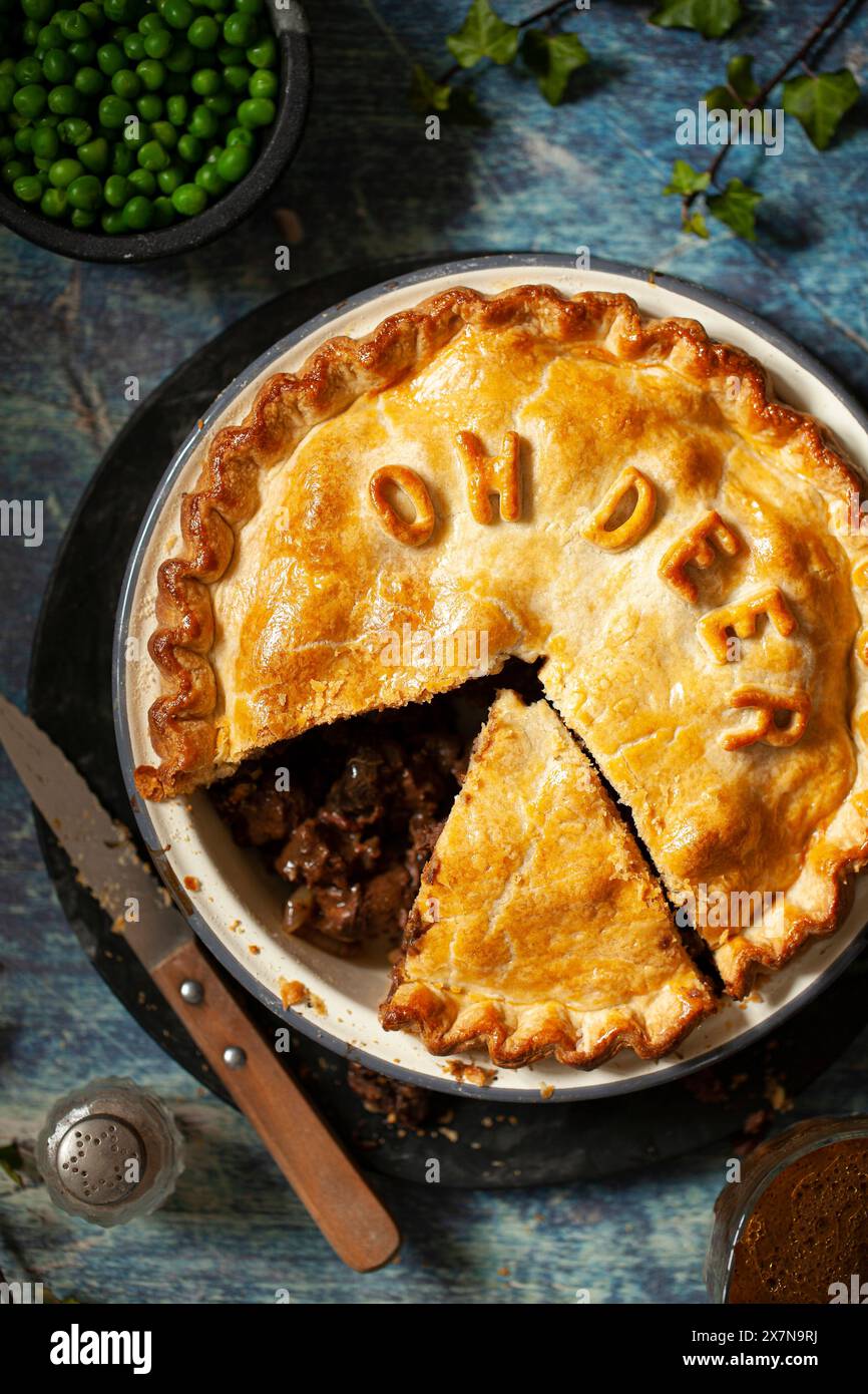 Venison Pie made with shortcrust pastry. Two slices have been cut, one ...