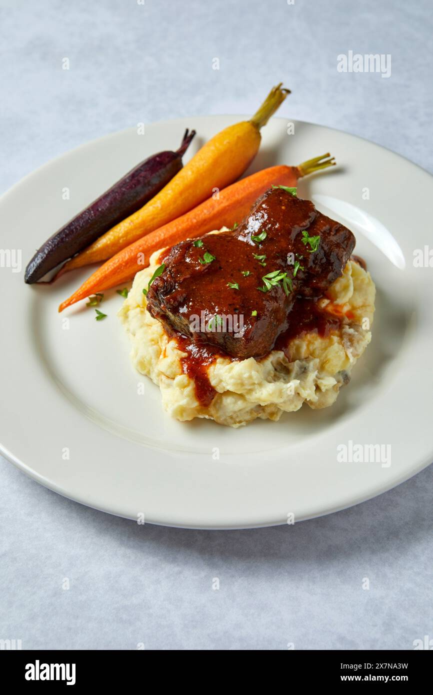Beef Short Ribs with Mashed Potatoes and Rainbow Carrots on a Neutral ...