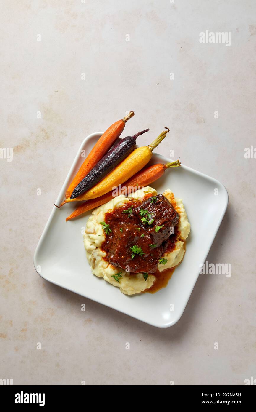 Beef Short Ribs with Mashed Potatoes and Rainbow Carrots on a Neutral ...