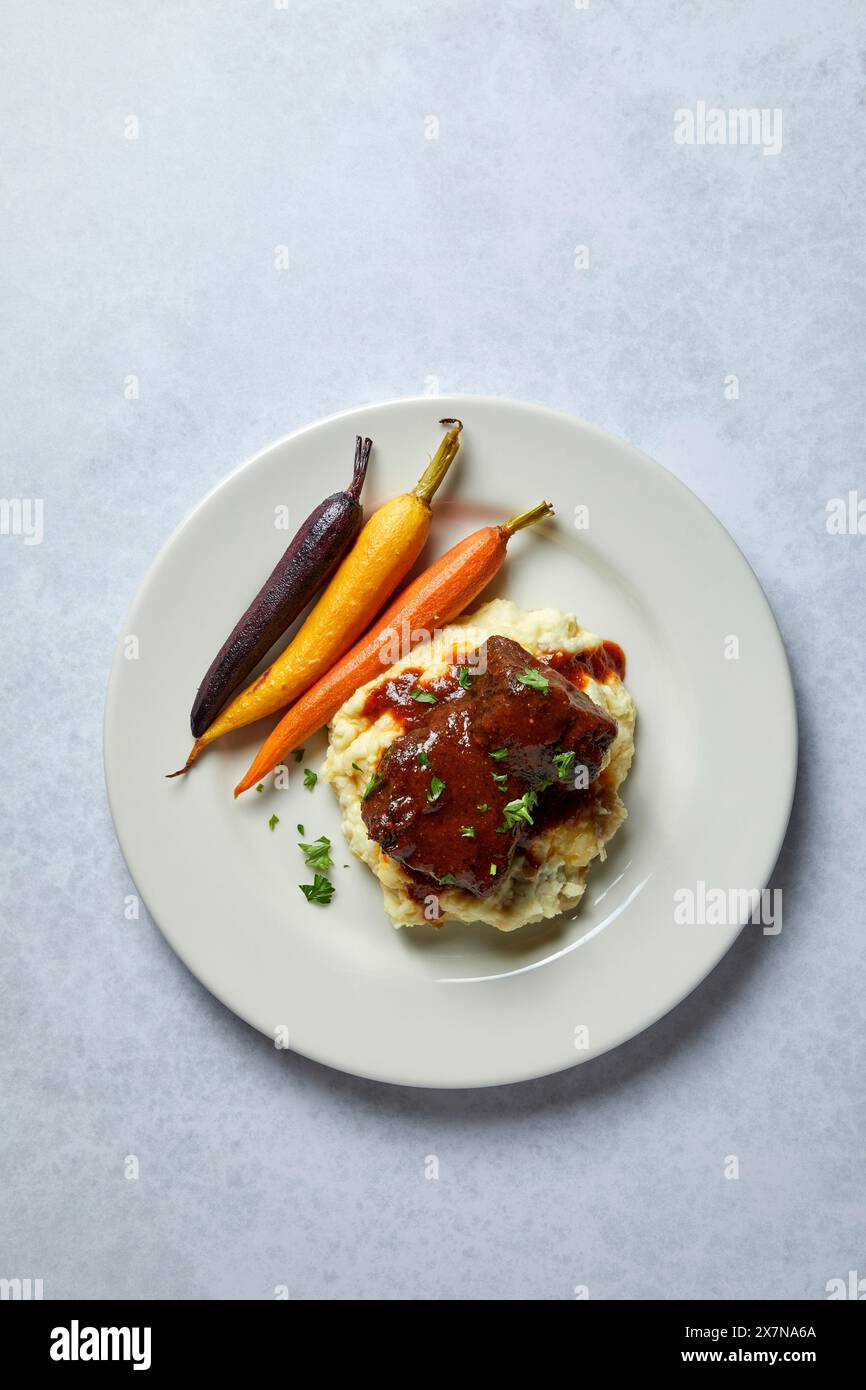 Beef Short Ribs with Mashed Potatoes and Rainbow Carrots on a Neutral ...