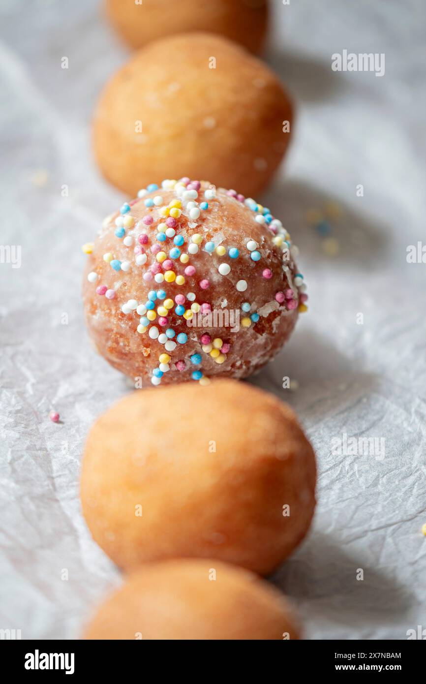 doughnut holes lined up. One had hundreds and thousands sprinkled on it ...